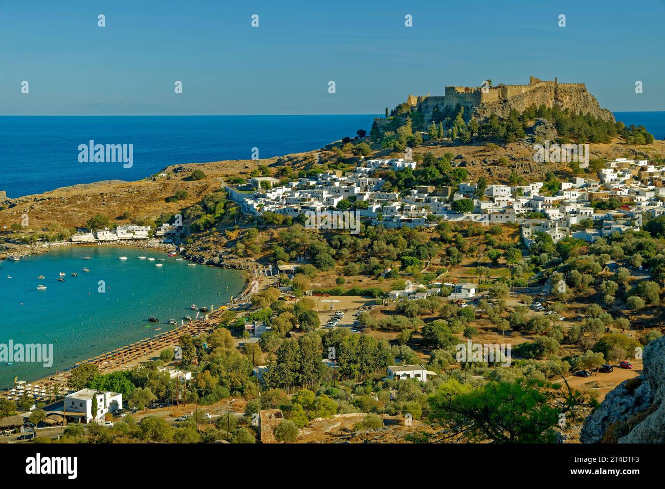 The town of Lindos on Rhodes island with the Lindos Acropolis on it's ...