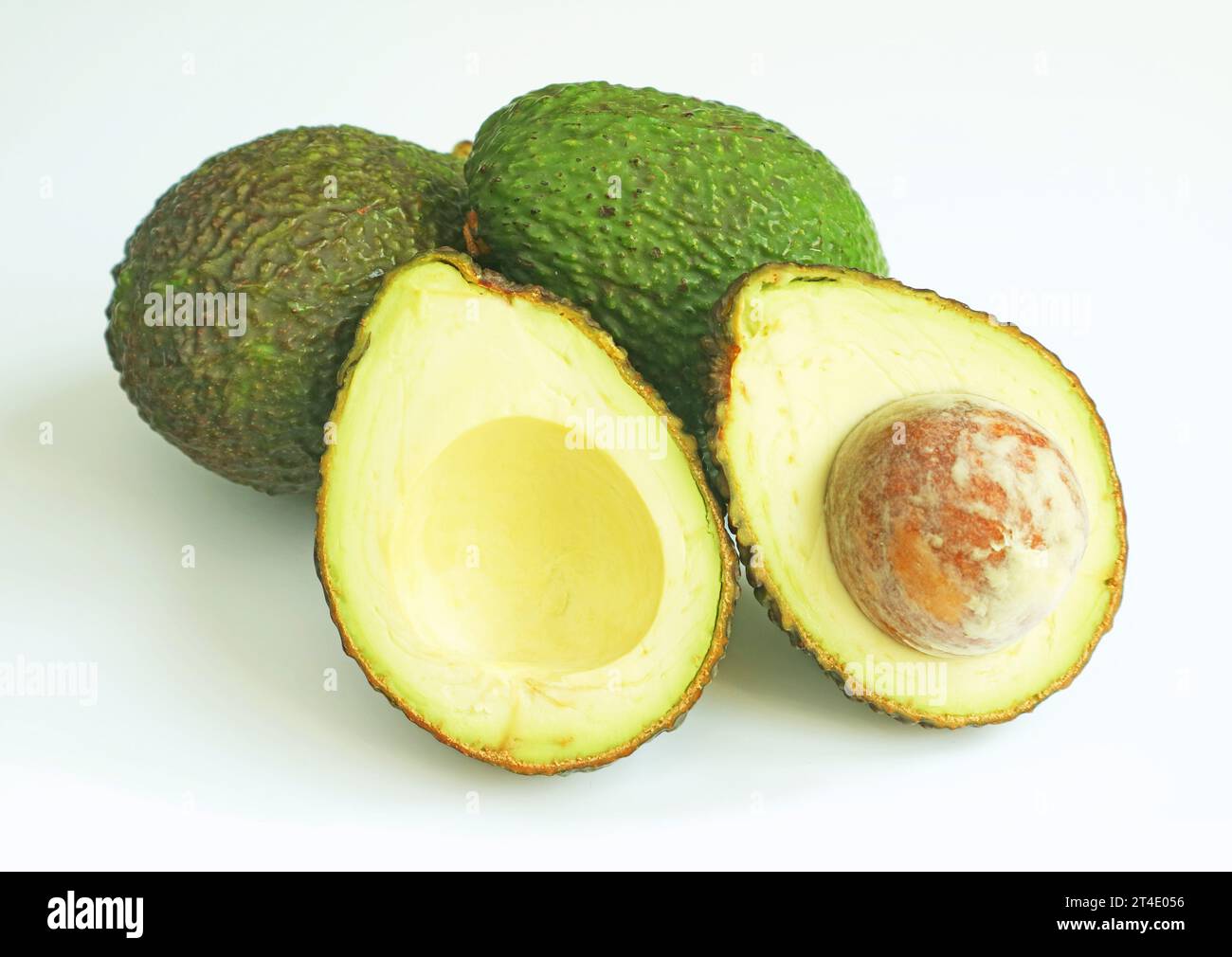 Heap of fresh ripe avocado whole fruits and cut in half isolated on ...