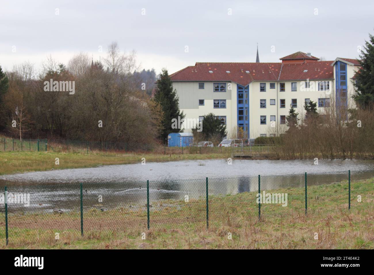 Flooded flood retention basin, a multi-storey house in the background ...
