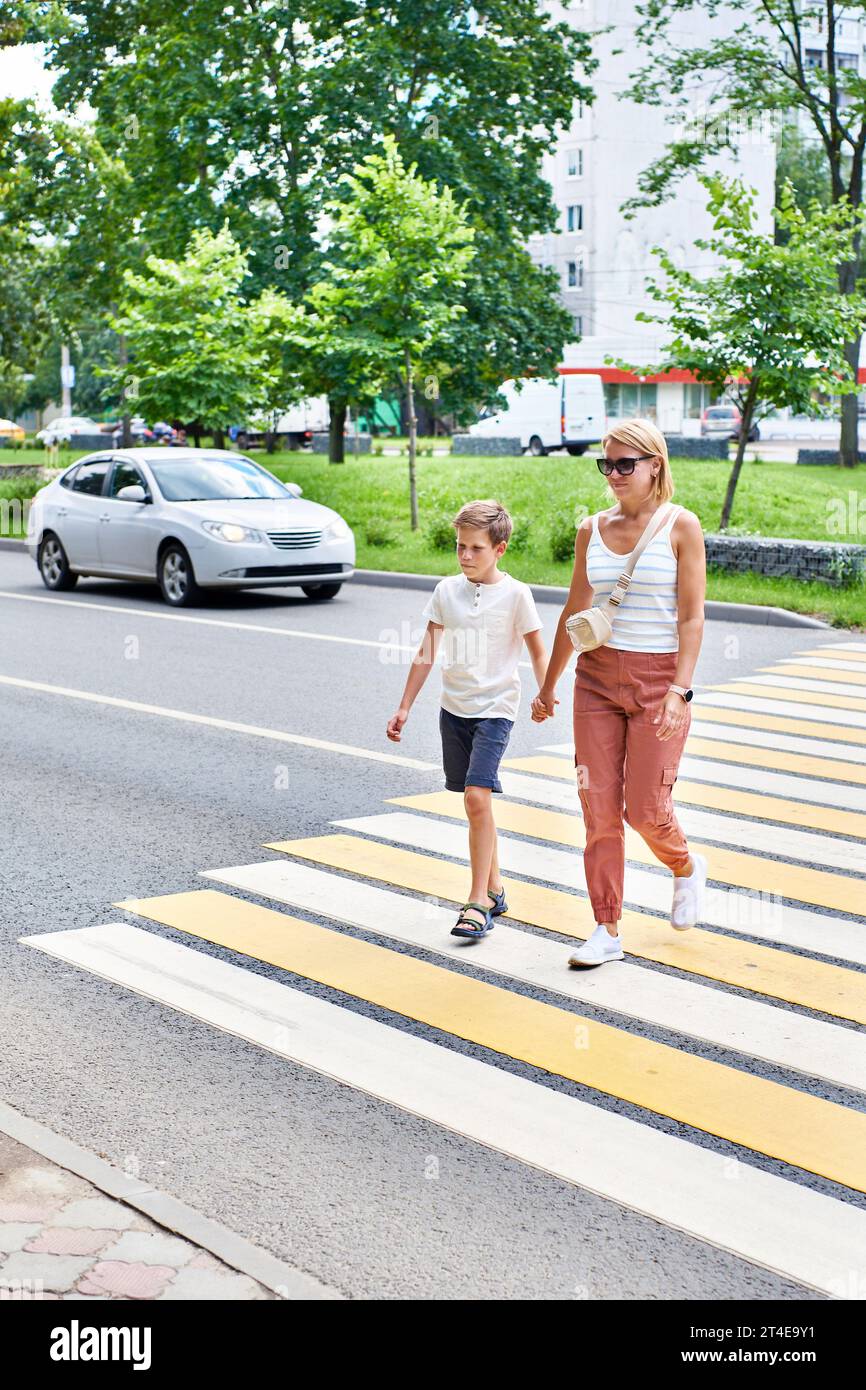 Mother and child walk on pedestrian crossing Stock Photo - Alamy