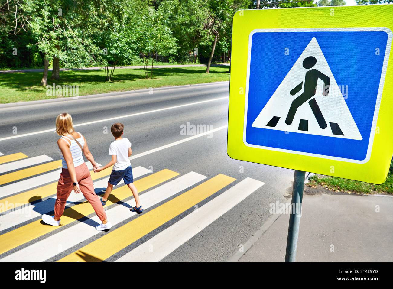 Mother and child walk on pedestrian crossing Stock Photo - Alamy