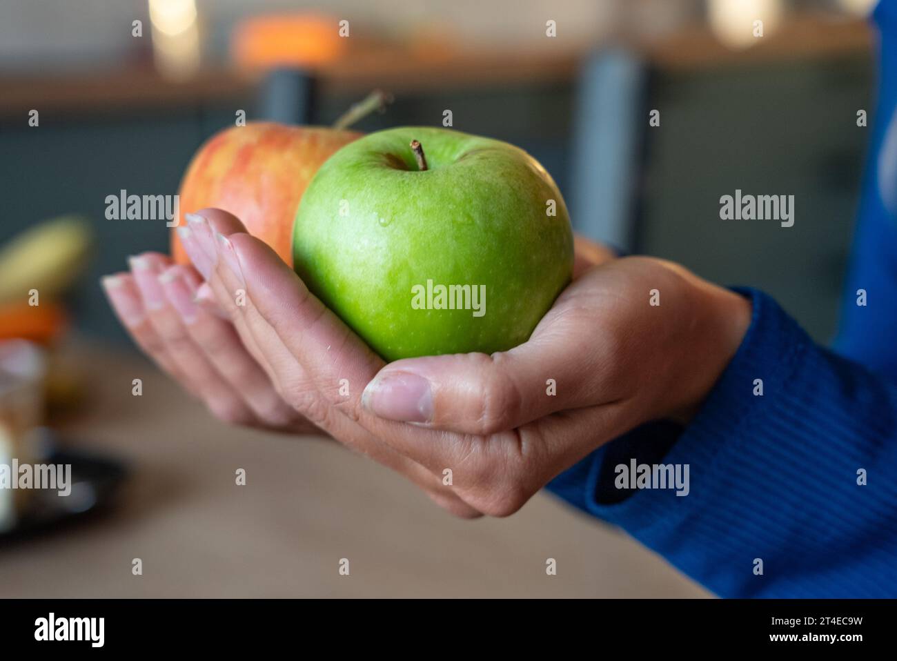 The woman holds food in her hand. The girl holds an apple. Apples in ...