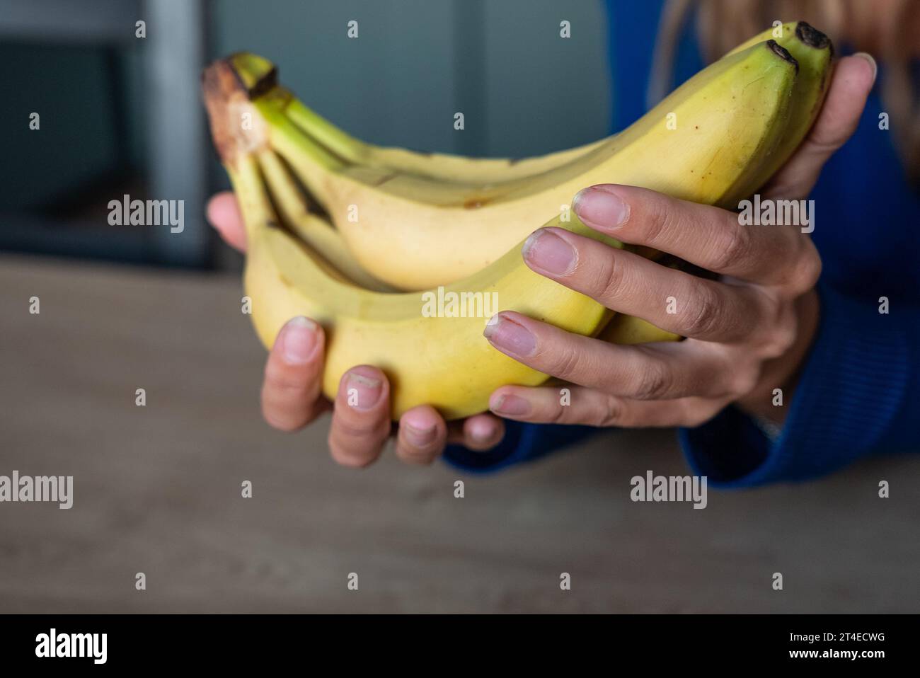 The woman holds fruits in her hand. The girl holds an banana. Bananas ...