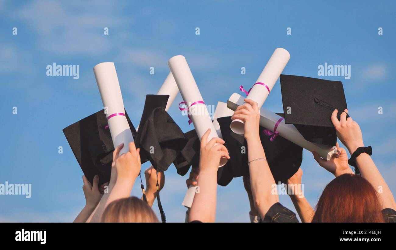 College graduates raise their caps and diplomas upward Stock Photo - Alamy