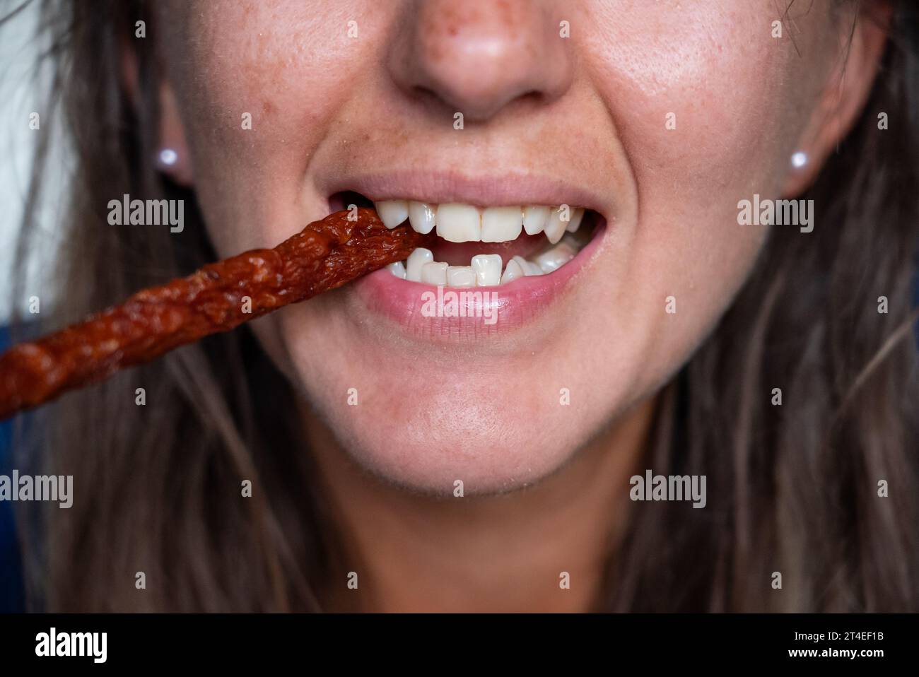Woman eats food. Woman eats Kabanos dry sausage. Close shot of girl ...