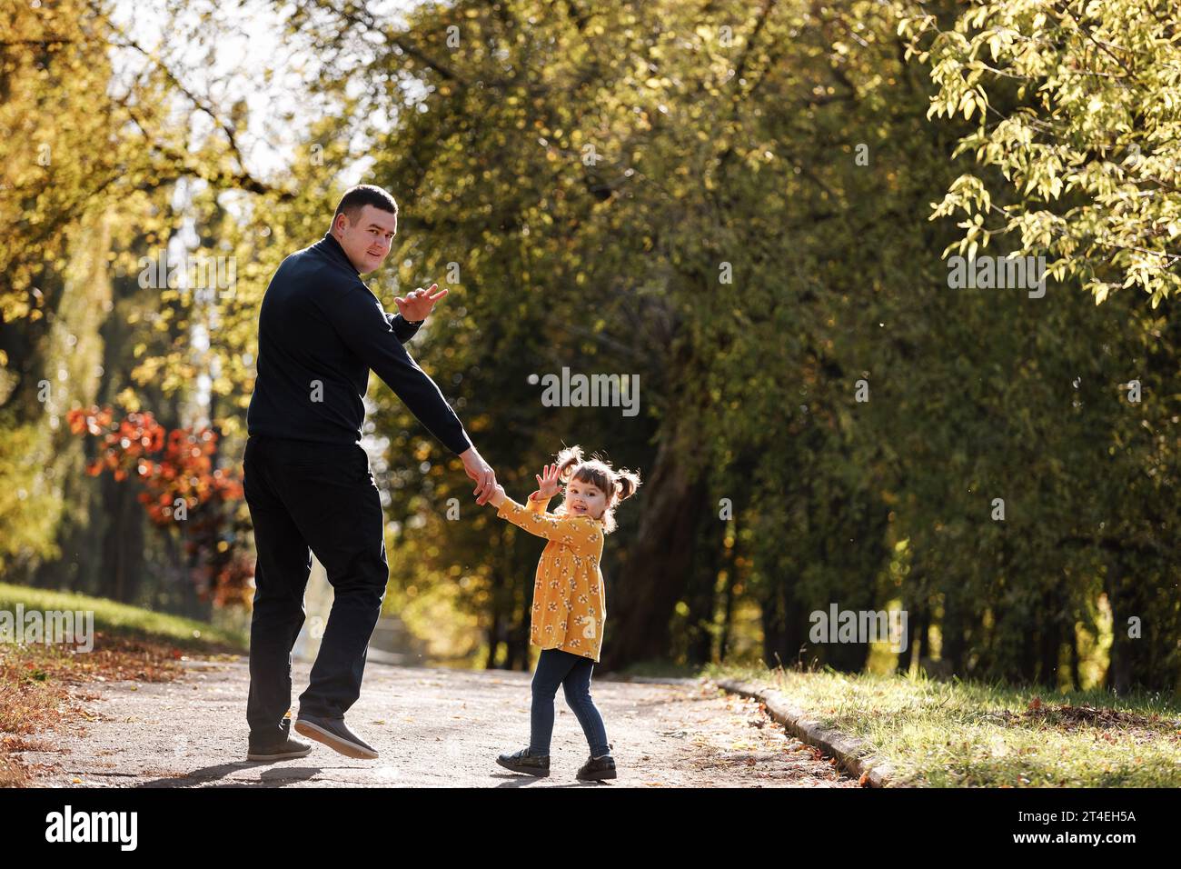 Happy fathers day. Dad holds hand his little daughter, walks, waves ...