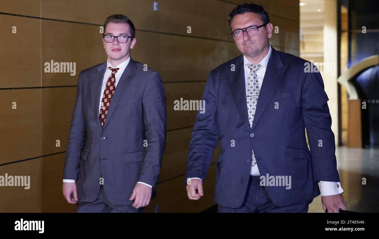30 October 2023, Bavaria, Würzburg: AfD politician Daniel Halemba (l) leaves the courtroom at ...