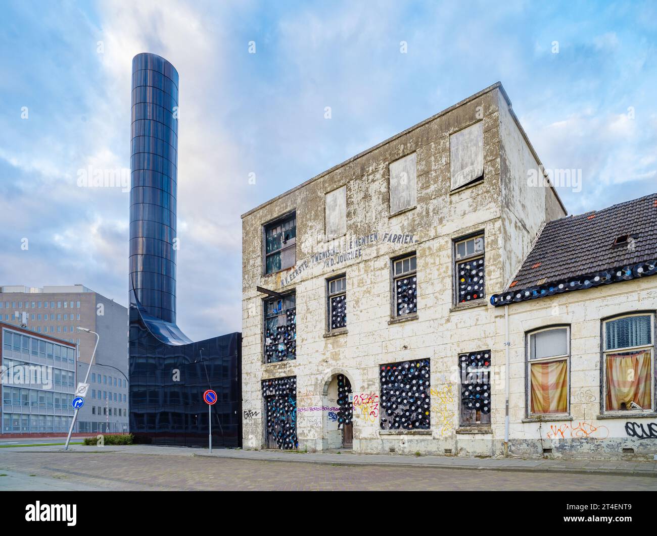 new factory building with chimney next to an old dacayed industrial ...
