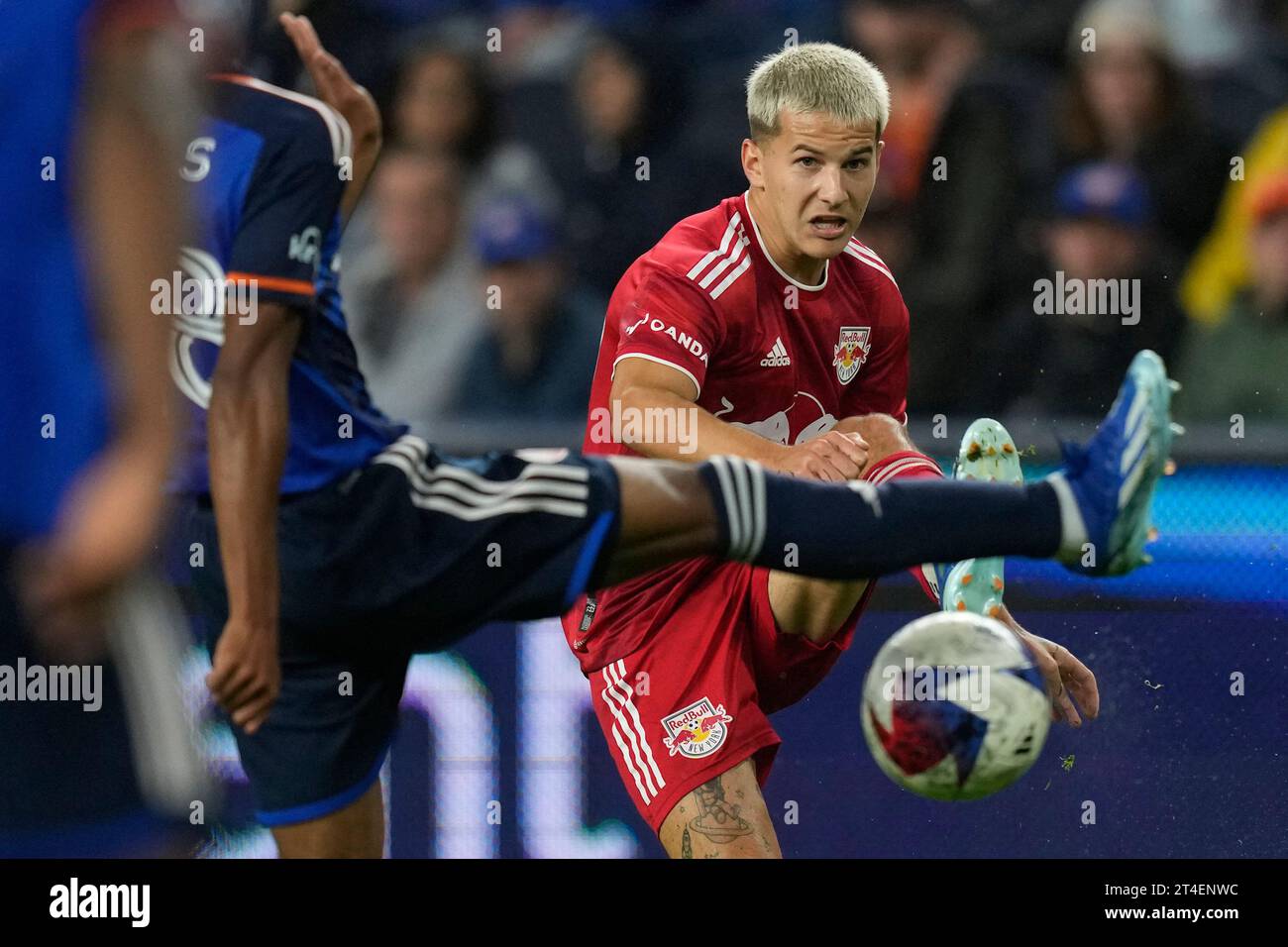 New York Red Bulls defender John Tolkin, right, kicks the ball as FC ...