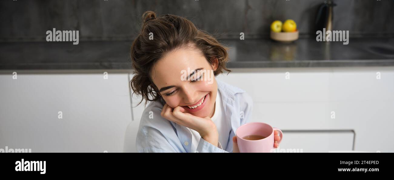Happy mornings. Portrait of happy brunette woman, drinks cup of coffee ...