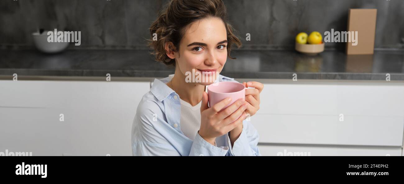 Happy mornings. Portrait of happy brunette woman, drinks cup of coffee ...