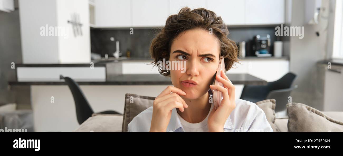 Close up portrait of woman talking on mobile phone with troubled face ...
