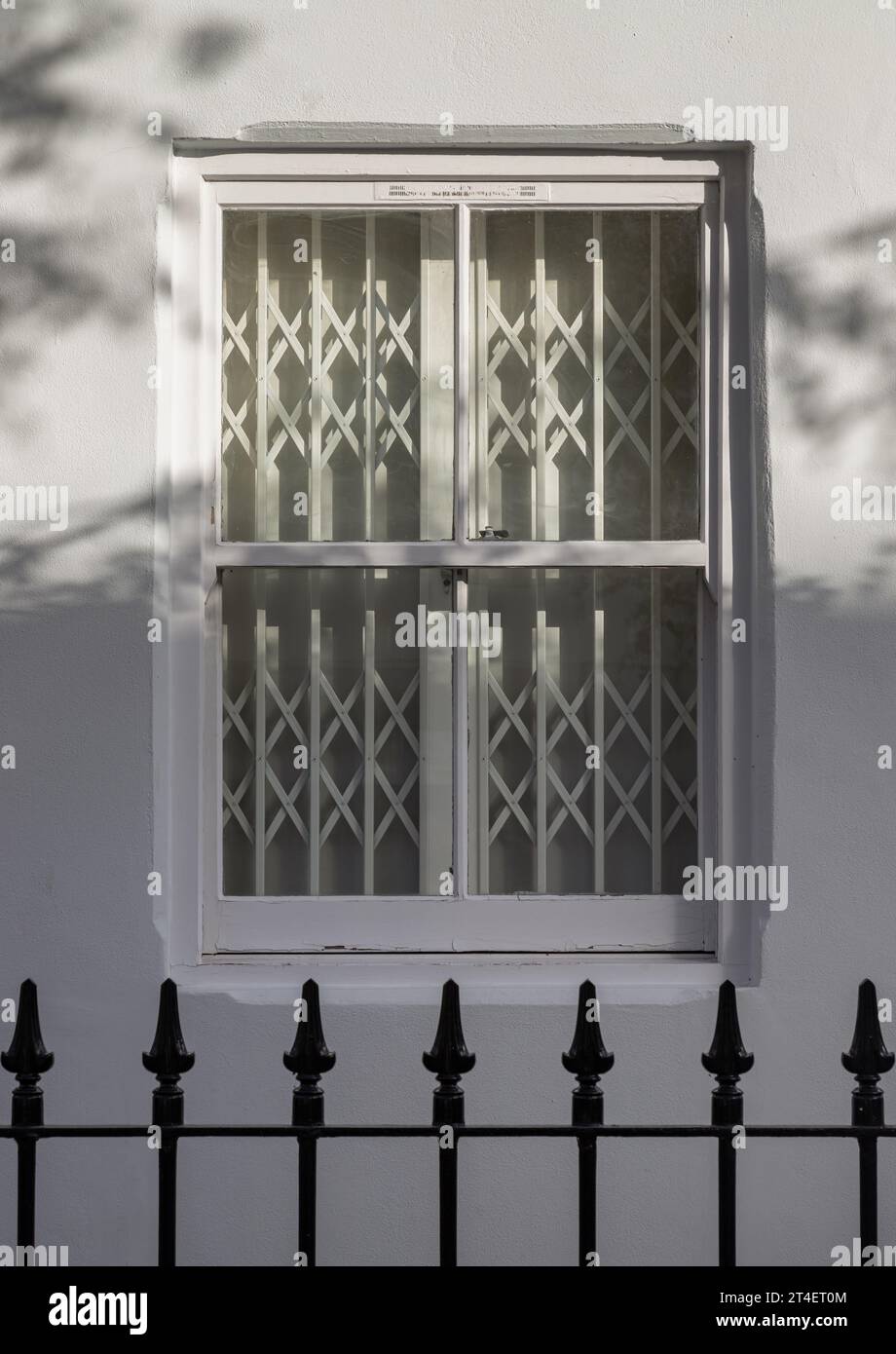 House exterior with wooden casement window on white wall with wrought ...