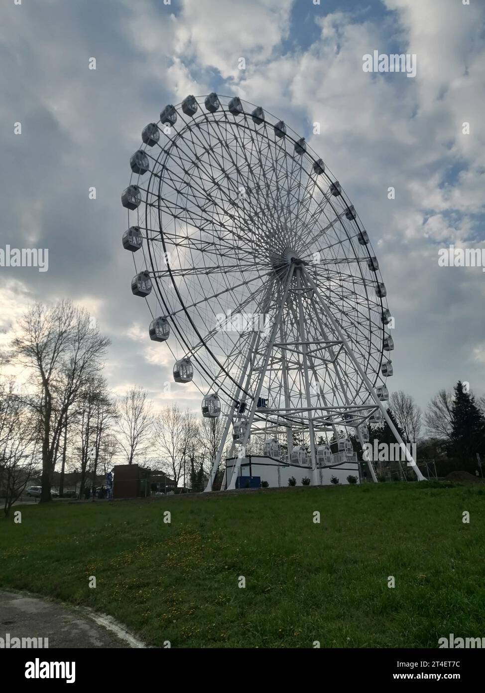 An outdoor scene featuring a large ferris wheel in the foreground ...