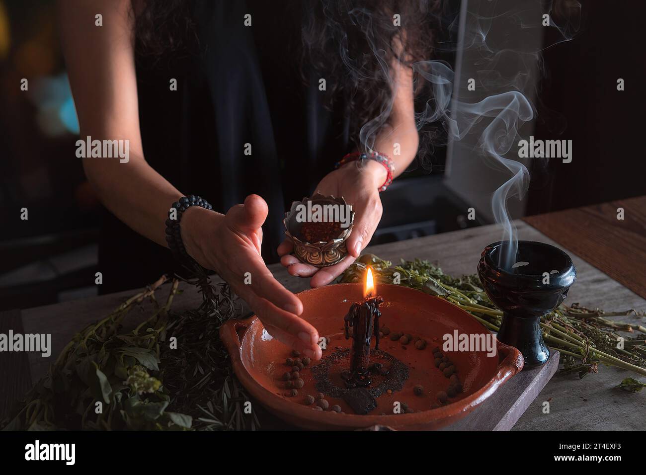 woman doing traditional ritual with black candle sea salt pepper in ...