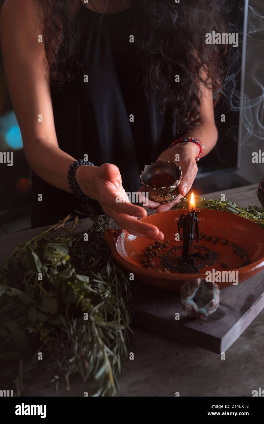 woman doing traditional ritual with black candle sea salt pepper in ...