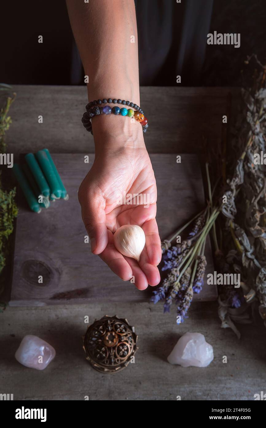 woman holding garlic with her hands for spiritual and traditional ...