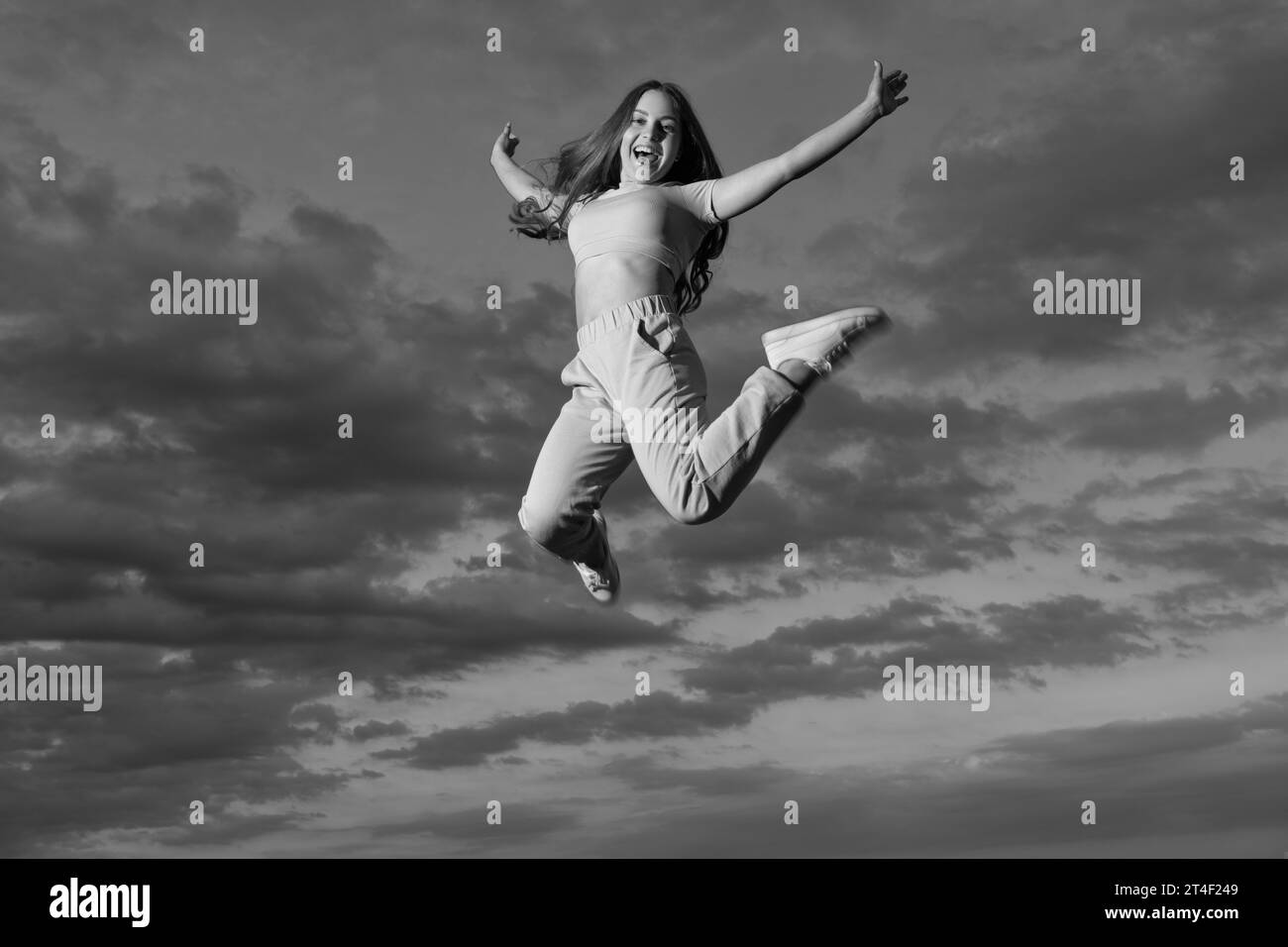 happy teen girl jumping high on sky background Stock Photo - Alamy