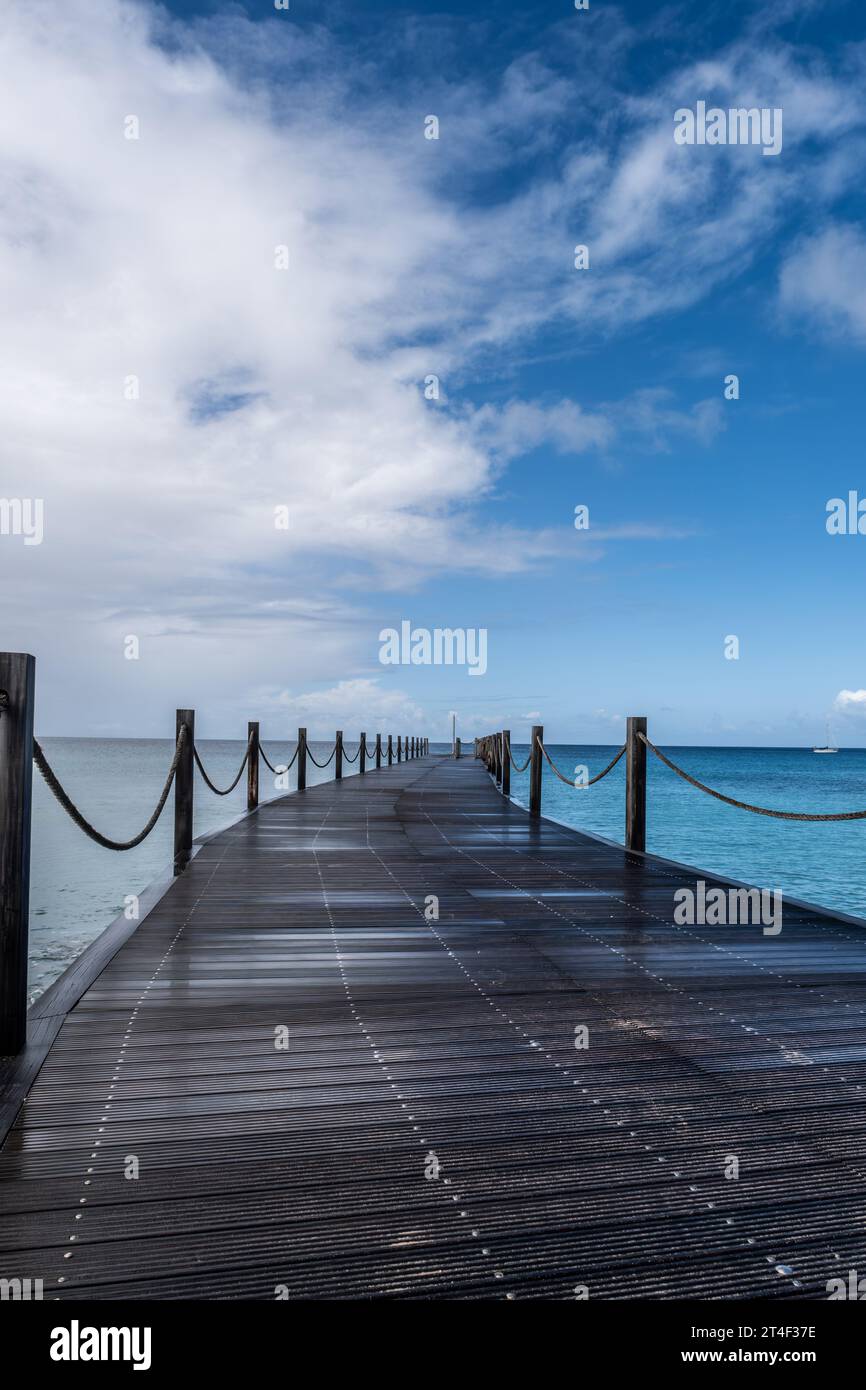 A boardwalk, pier, jetty leading out into a blue tropical sea Stock ...