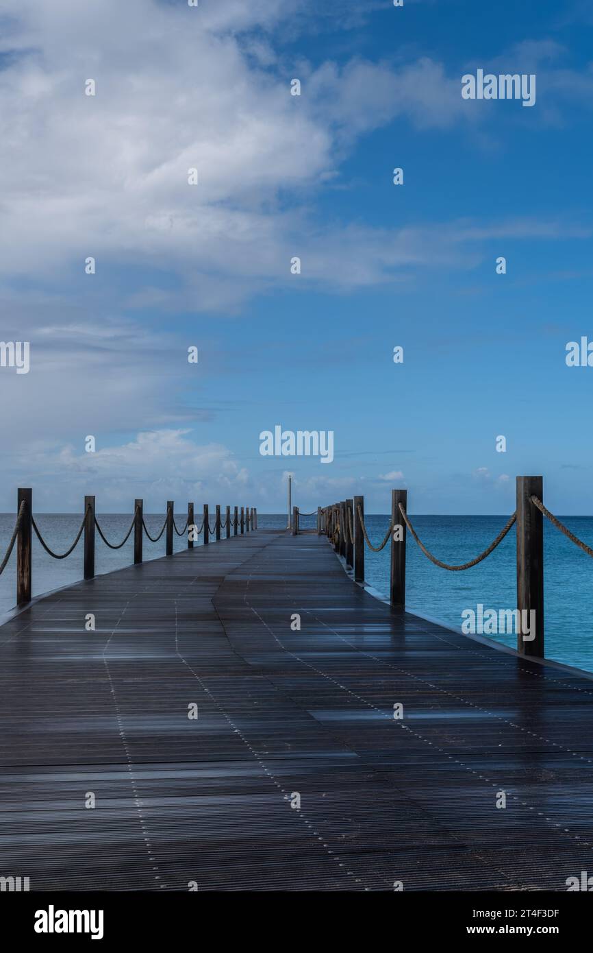 A boardwalk, pier, jetty leading out into a blue tropical sea Stock ...