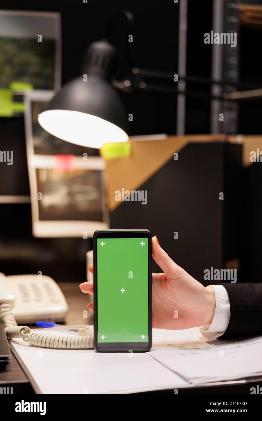 Private detectives showing mobile phone with green screen mock up ...