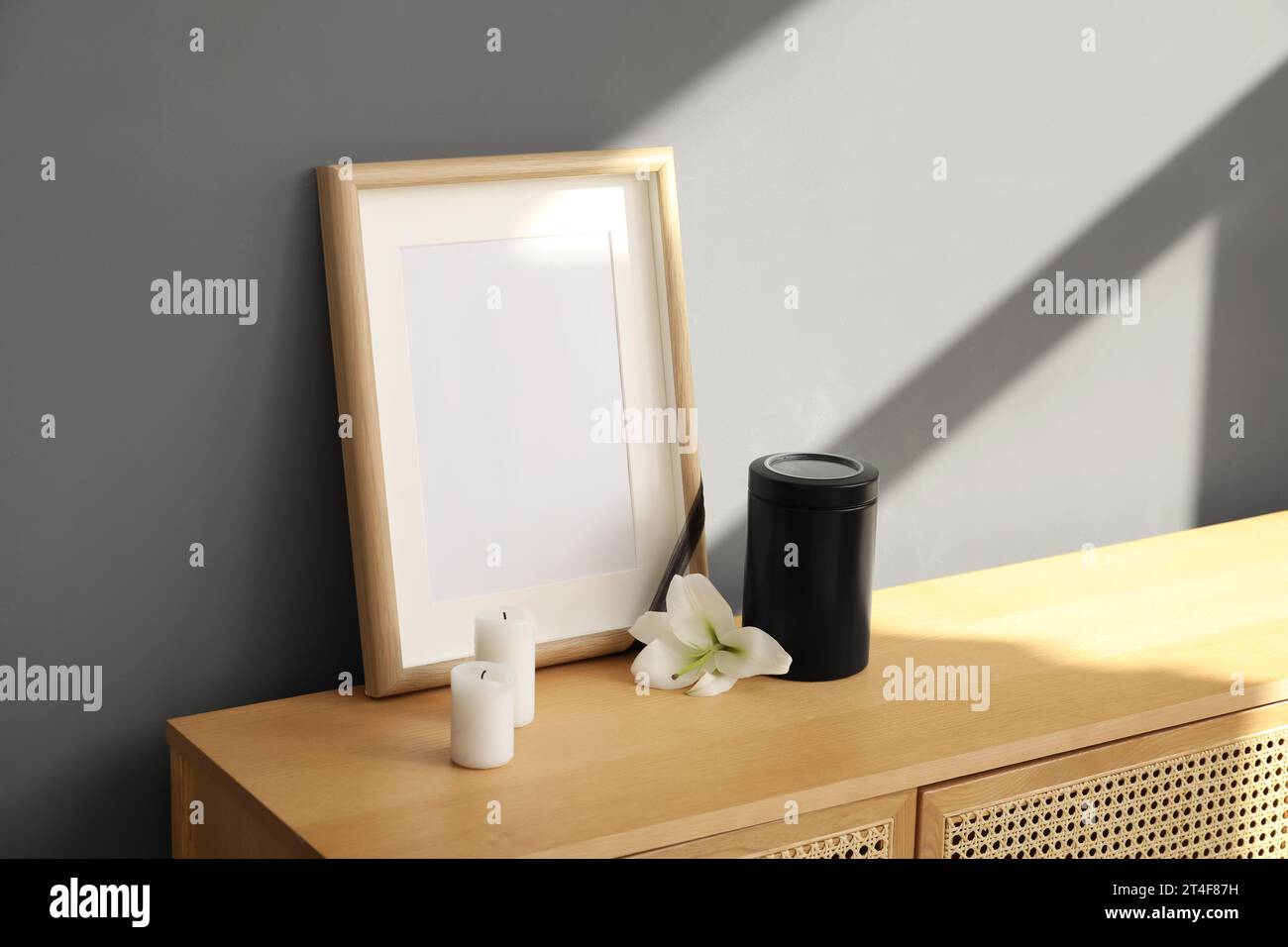 Blank funeral frame, mortuary urn, candles and lily flower on wooden ...