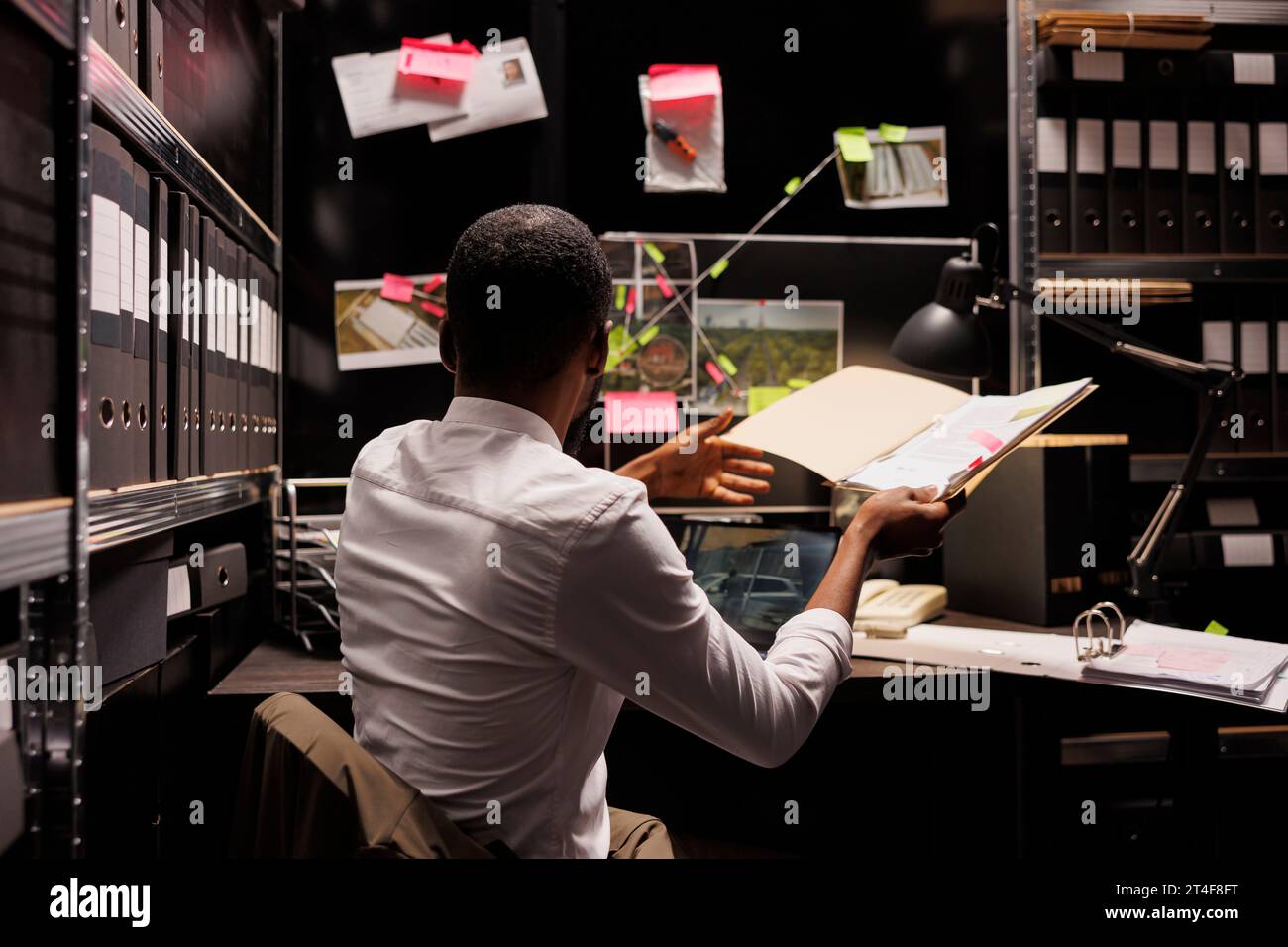 Detective looking at evidence on board and comparing with police report ...