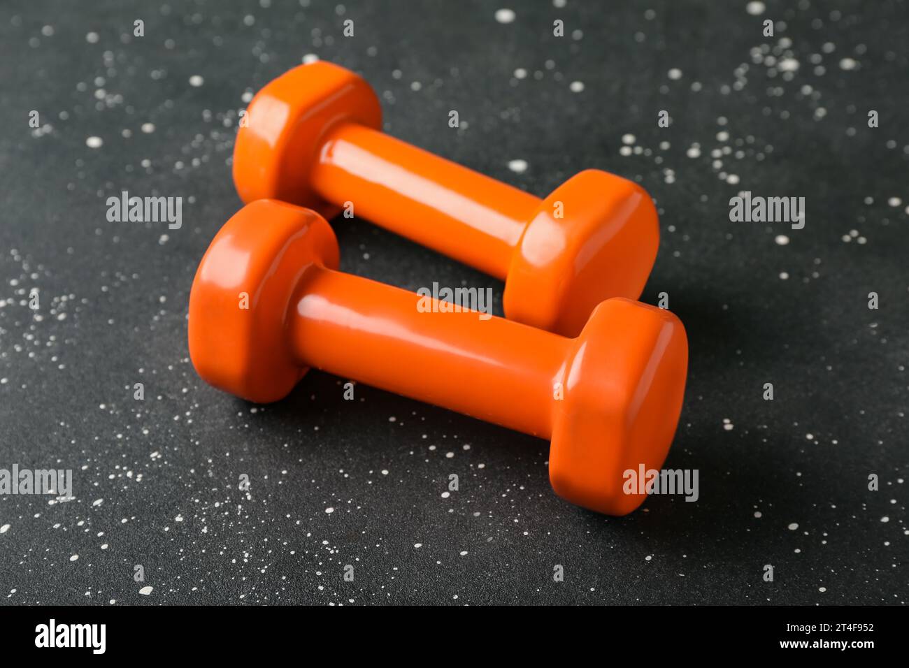 Orange dumbbells on black background Stock Photo - Alamy