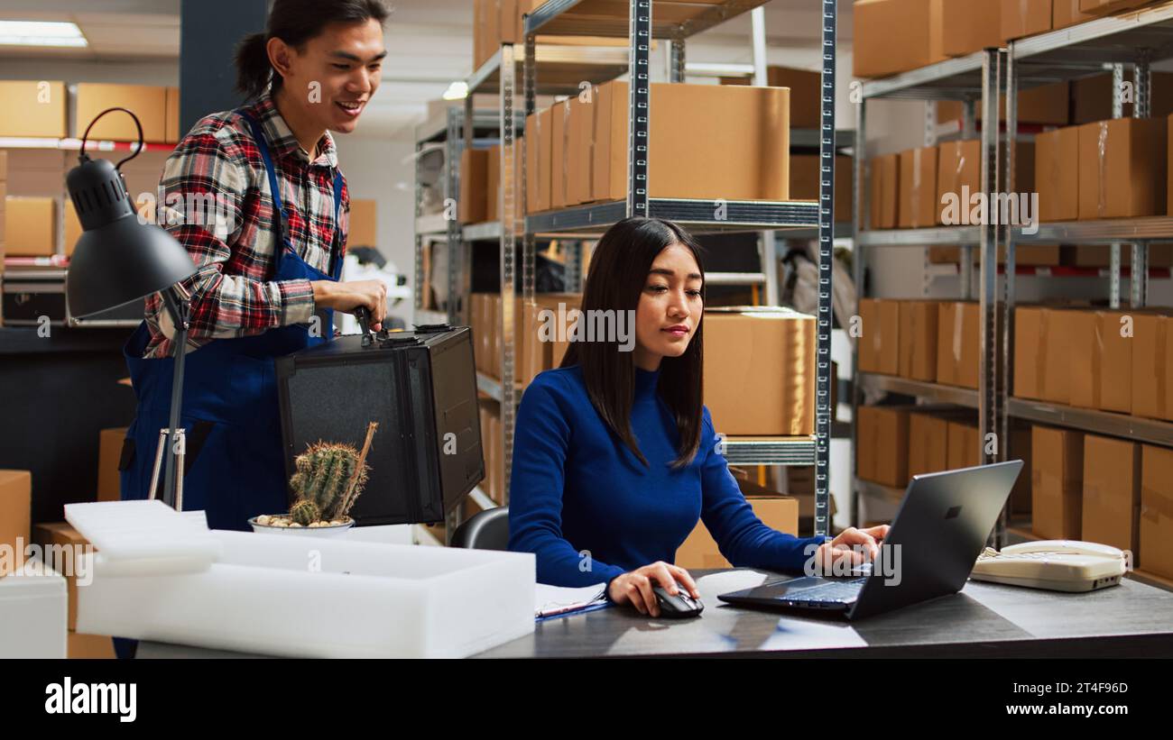 Asian team working on product inventory in warehouse, checking ...