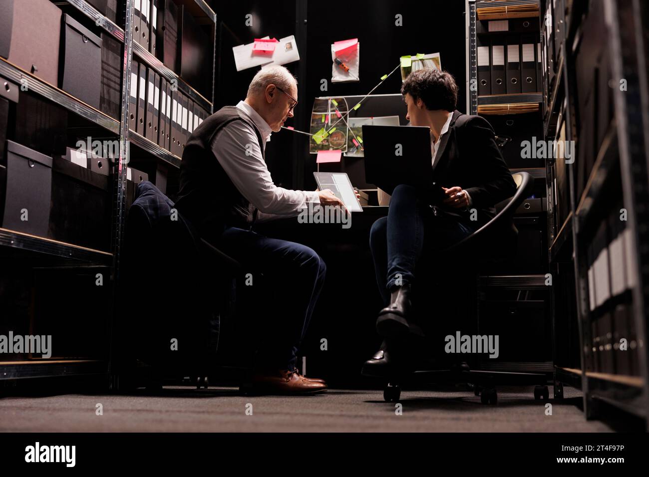 Elderly police officer examining crime evidence files, discussing ...