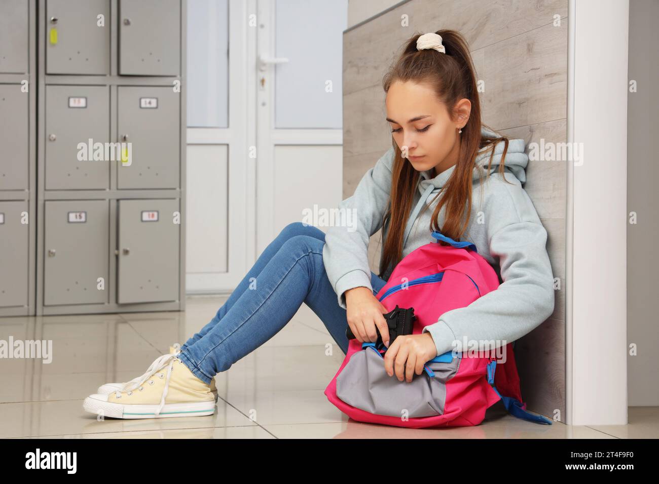 Female student with gun in backpack at university hall Stock Photo - Alamy