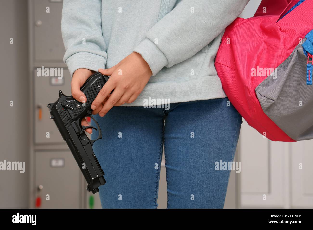 Female student with gun at university hall, closeup Stock Photo - Alamy