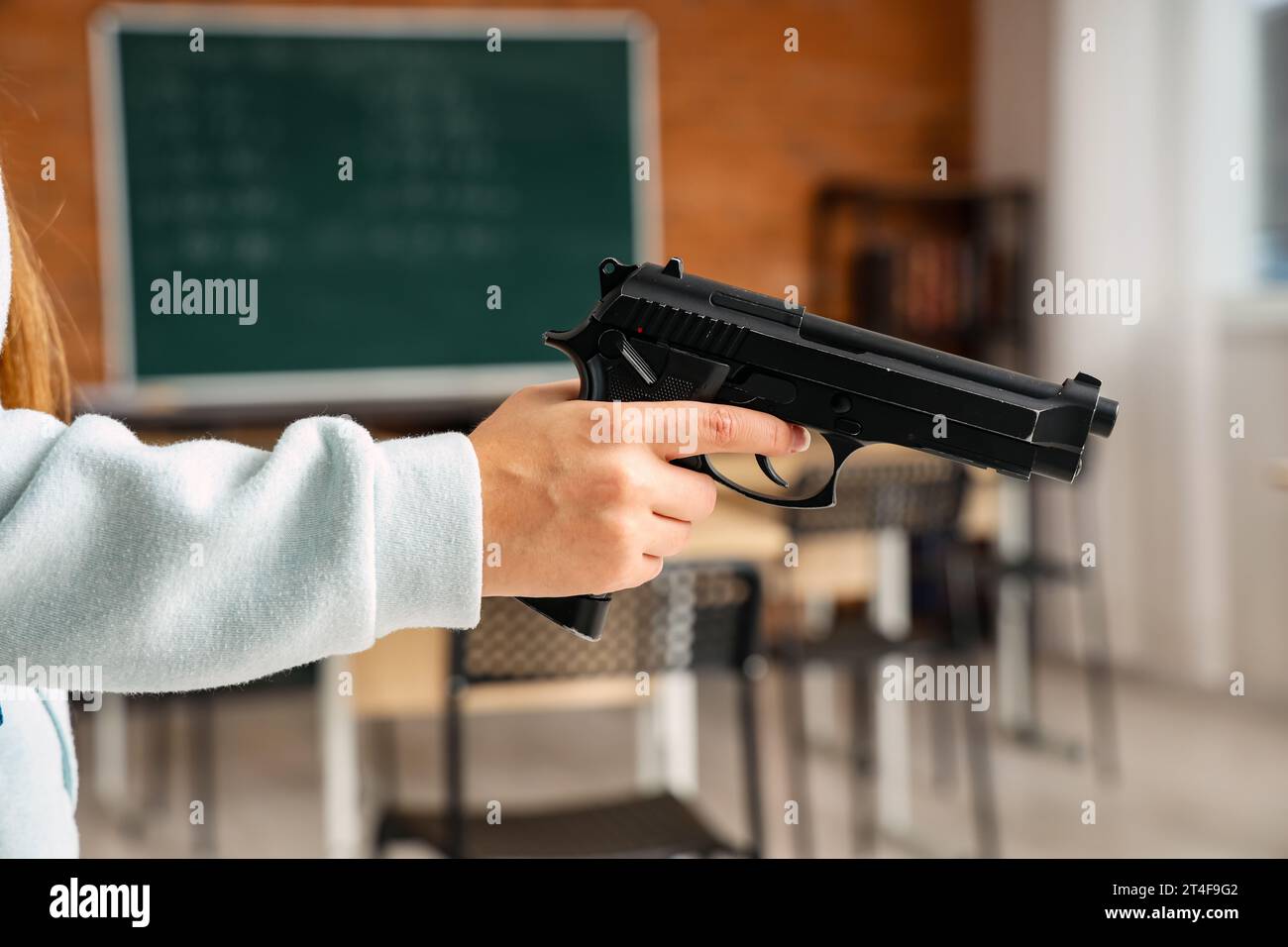 Female student with gun in classroom, closeup Stock Photo - Alamy