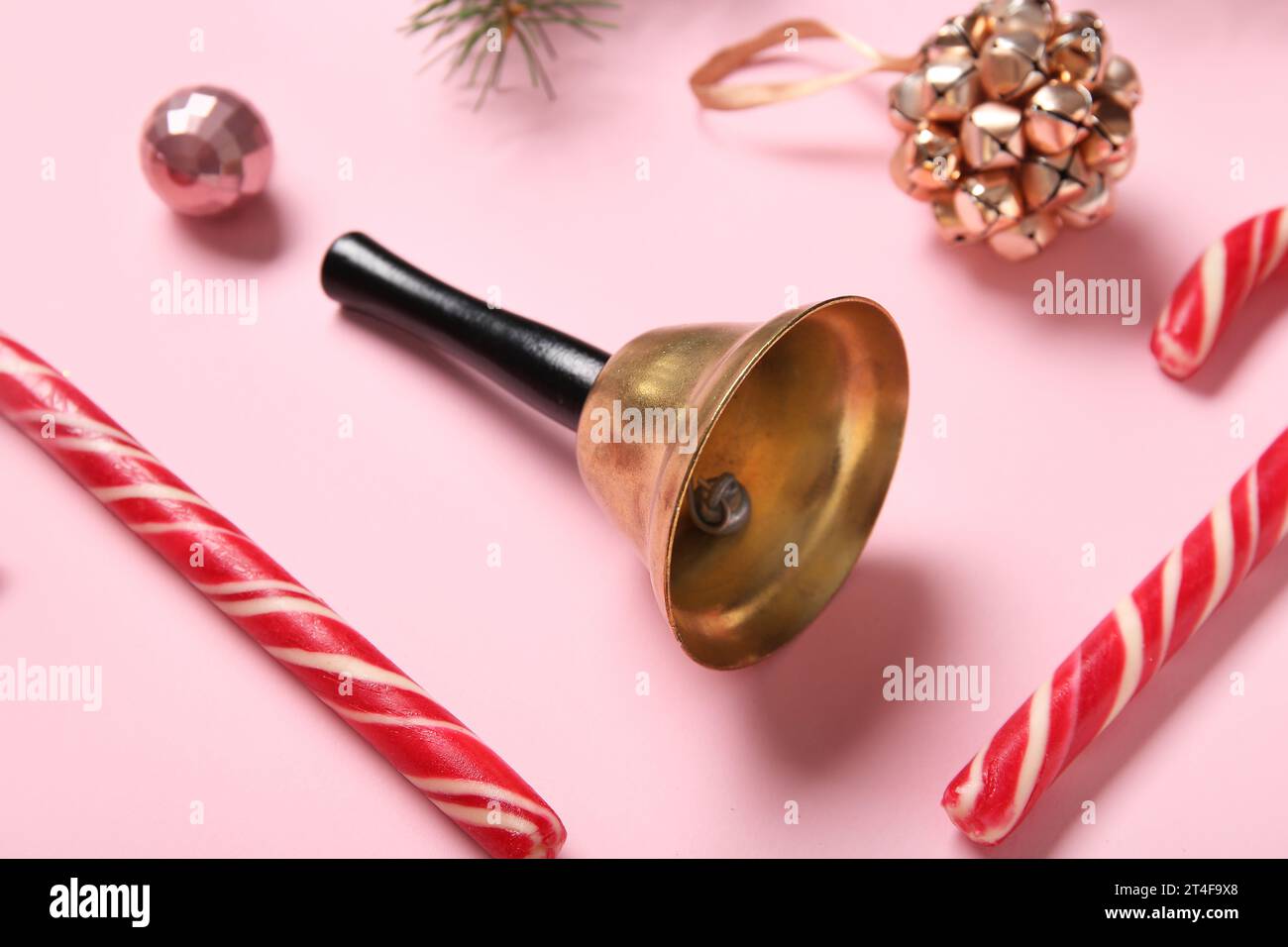 Christmas bell with candy canes and beautiful decorations on pink ...