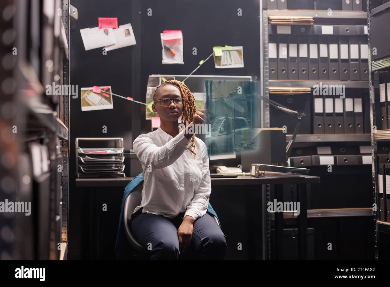 African american detective examining holographic image in evidence room ...