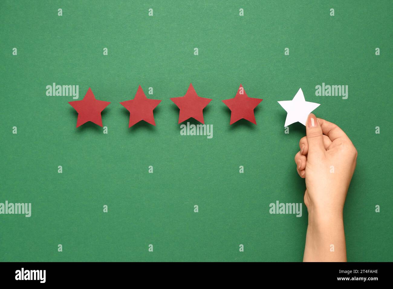 Female hand with four out of five stars rating on green background ...
