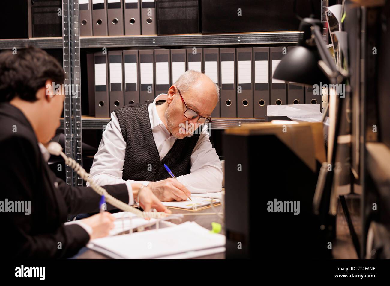Elderly police officer checking crime scene evidence in arhive room ...