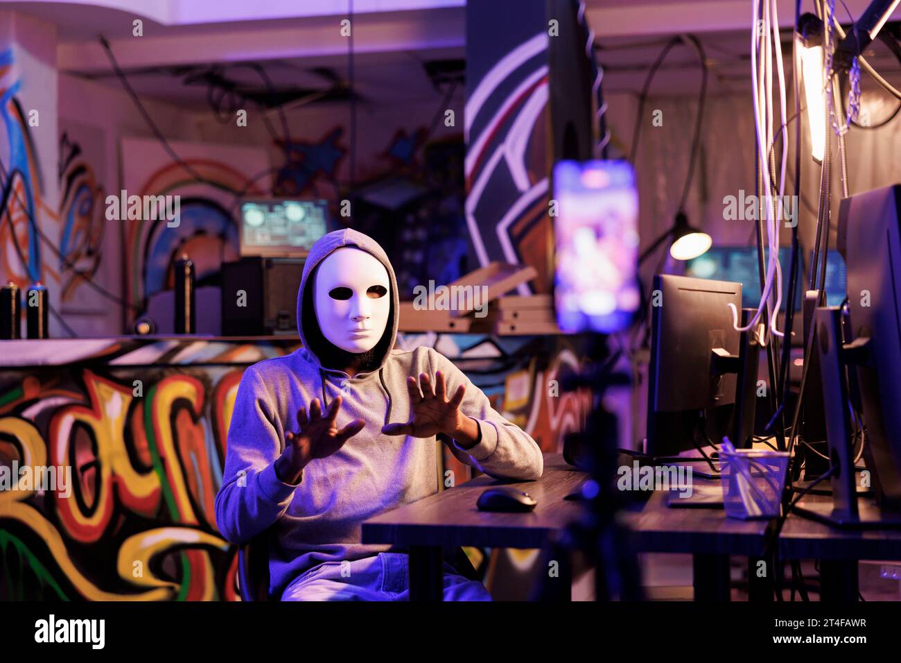 Hacker in anonymous mask live streaming illegal content online on ...