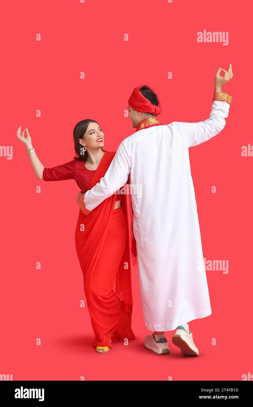 Beautiful Indian couple dancing on red background Stock Photo - Alamy