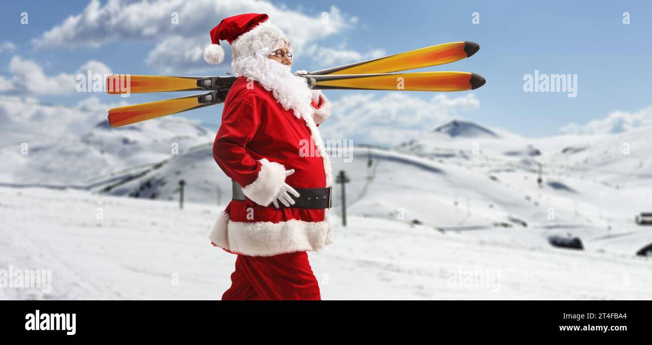 Santa Claus walking and carrying skis on shoulder on a snowy hill Stock ...