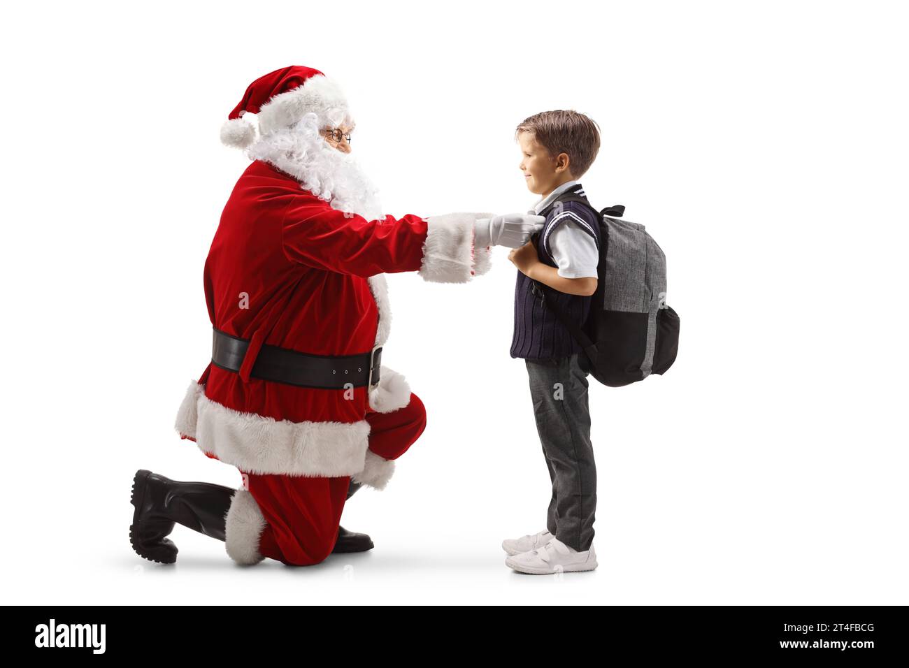 Full length profile shot of a santa claus helping a boy to put a ...
