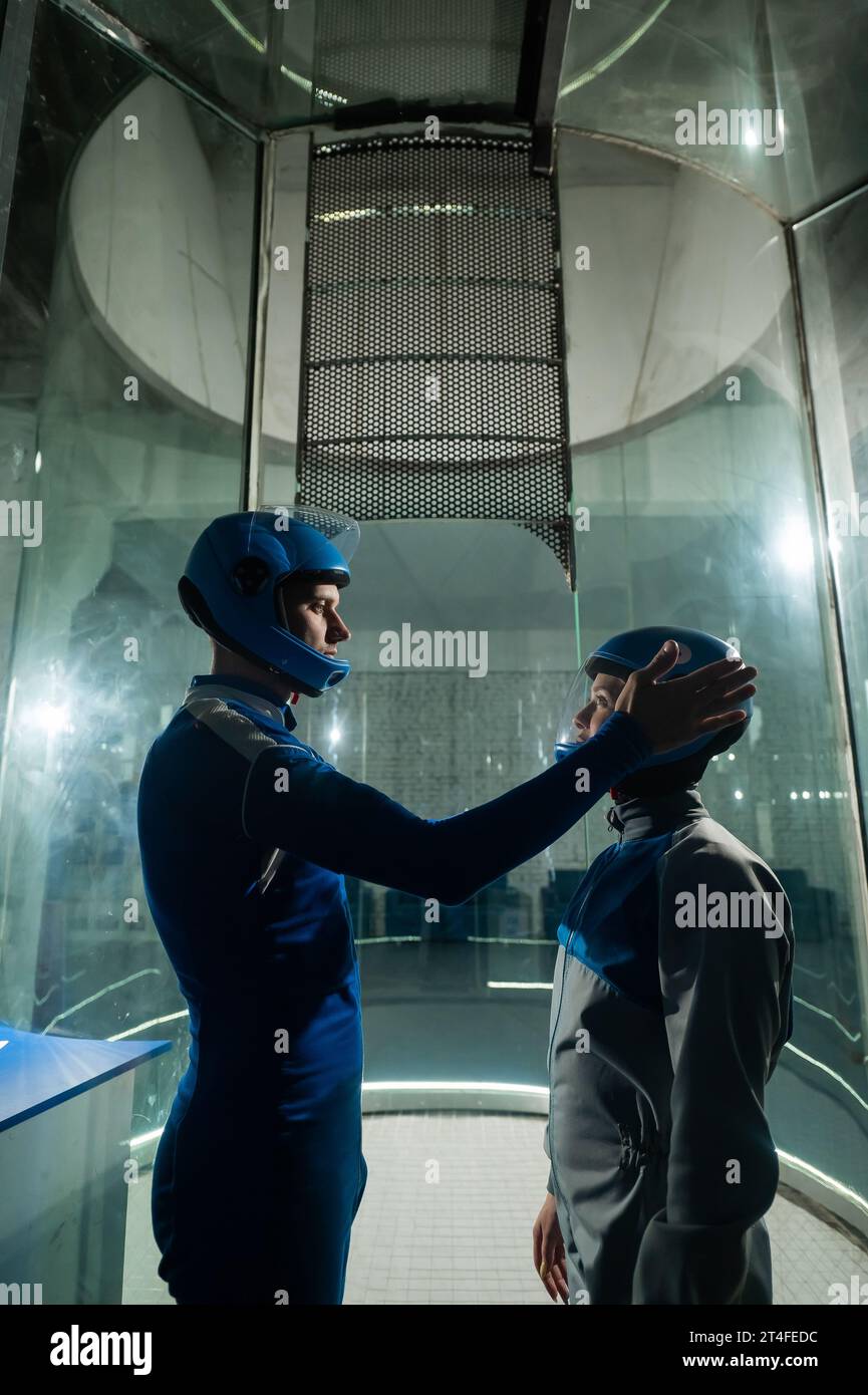 A male instructor teaches a woman how to fly in a wind tunnel. Free ...