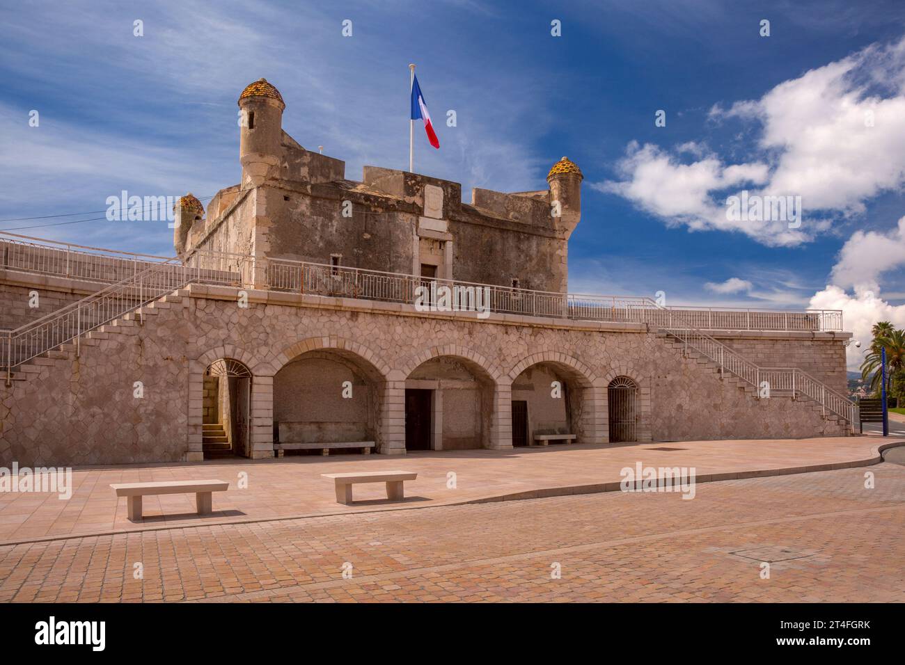 The French flag flies over Old bastion fort on the seashore in Menton ...