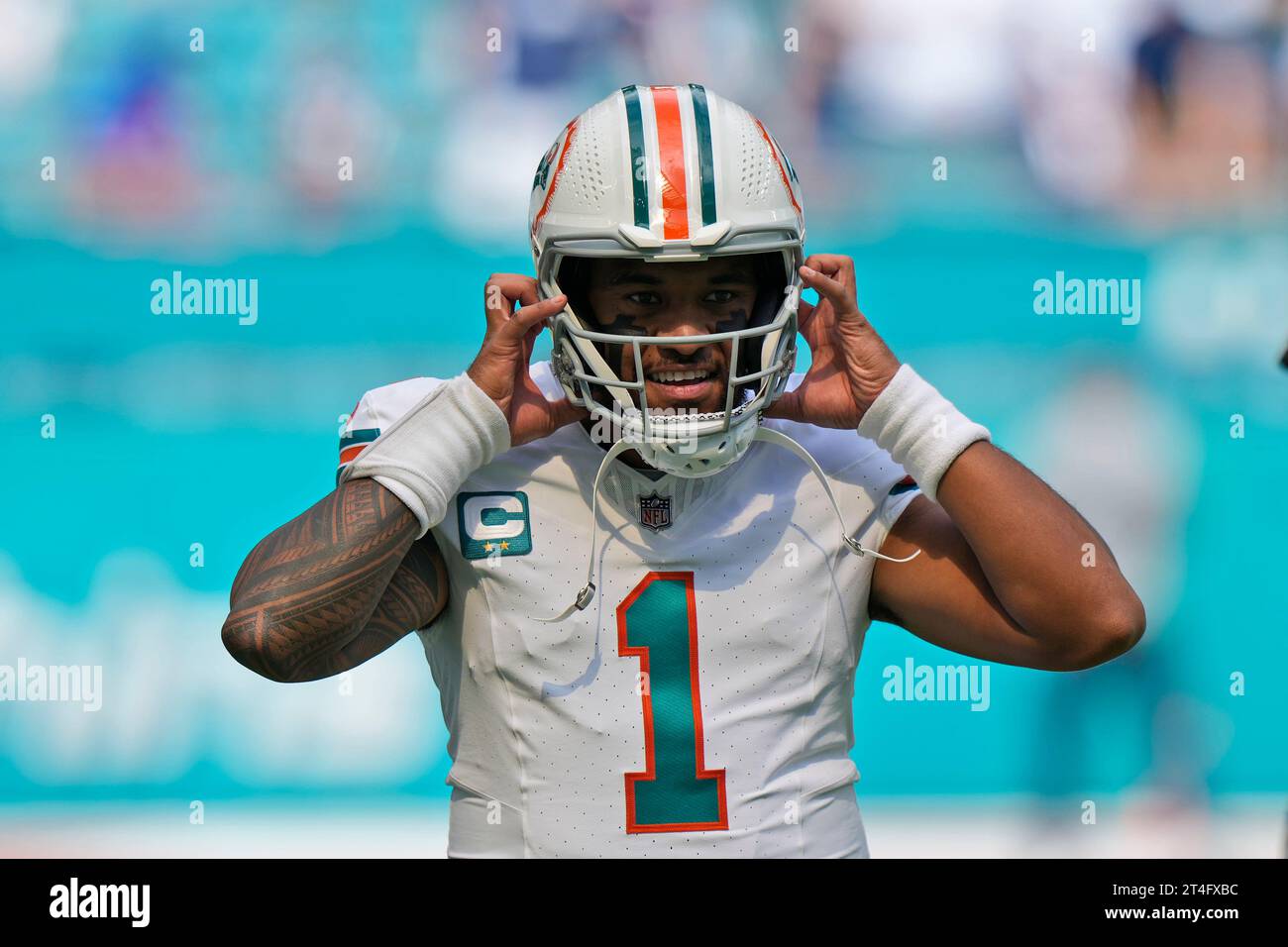 Miami Dolphins quarterback Tua Tagovailoa takes off his helmet as he ...