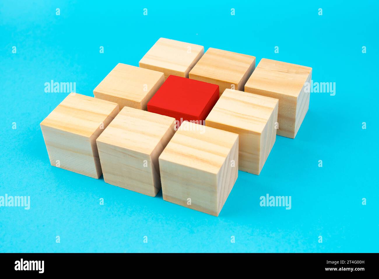 Red wooden block standing out from the group on blue background ...