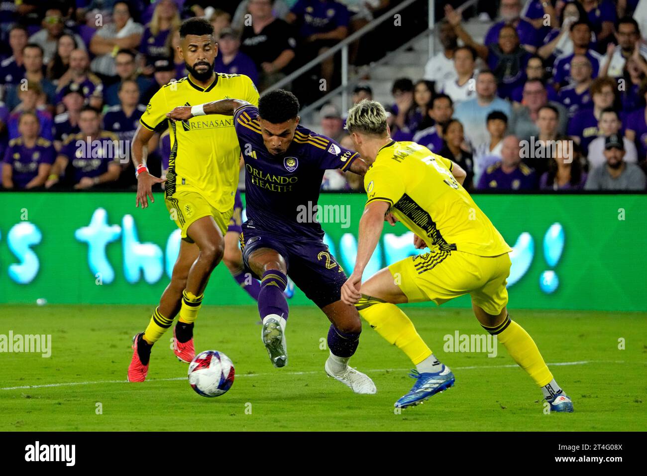 Orlando City midfielder Junior Urso, center, tries to move the ball ...