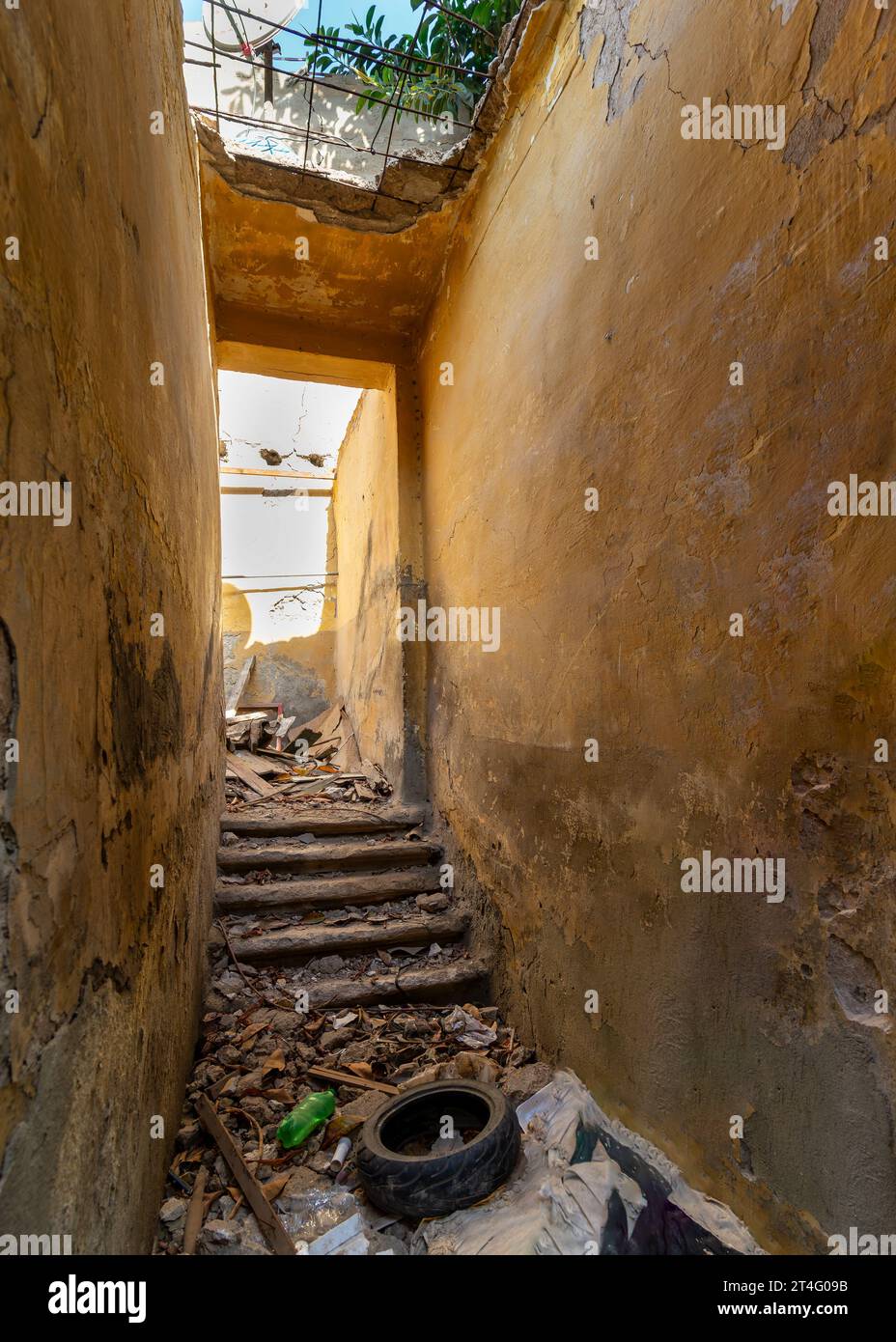 Narrow passage with collapsed ceiling and collapsed staircase in ruins ...