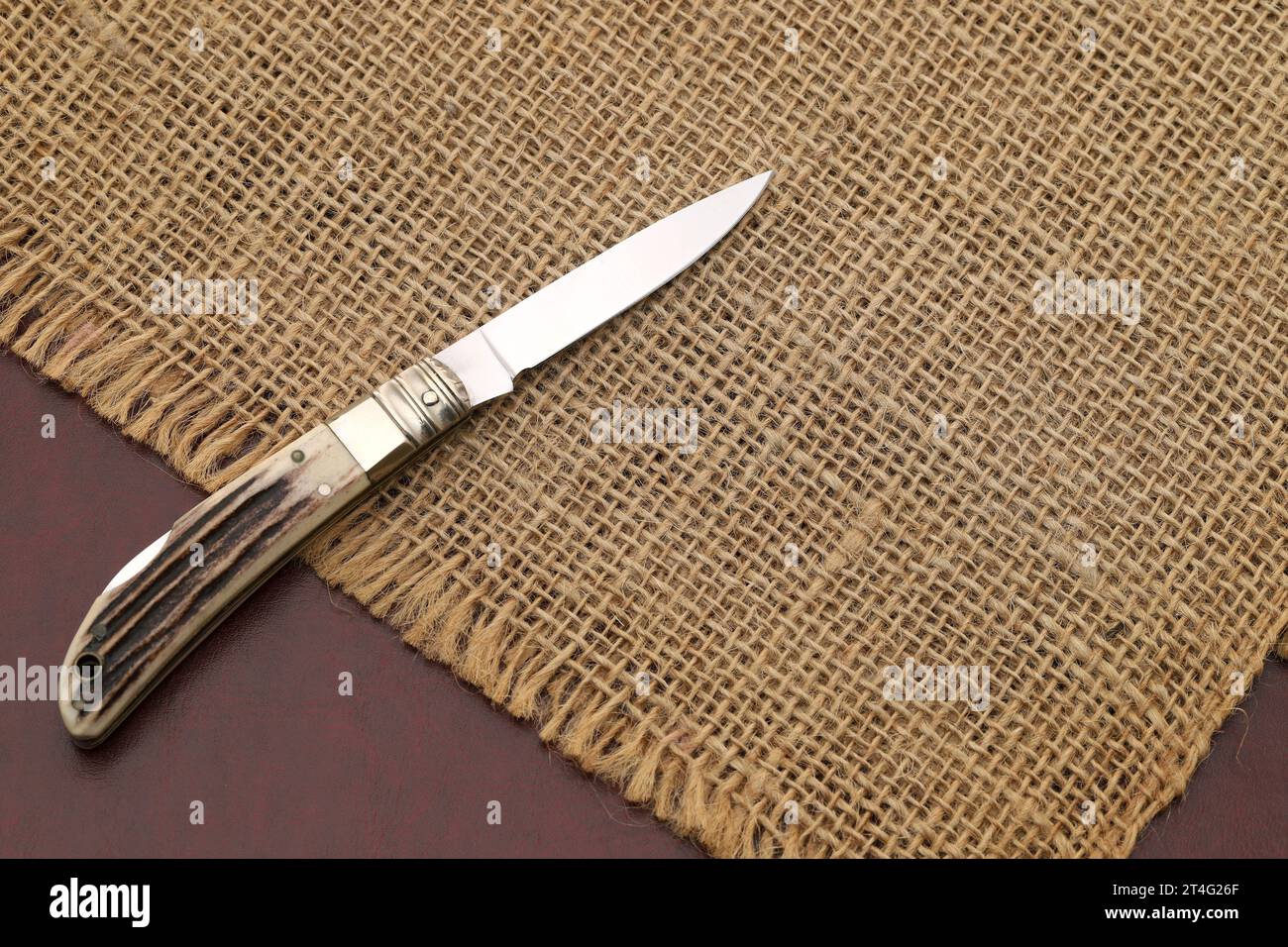 Close up photo of small folding knife on hemp cloth background Stock ...
