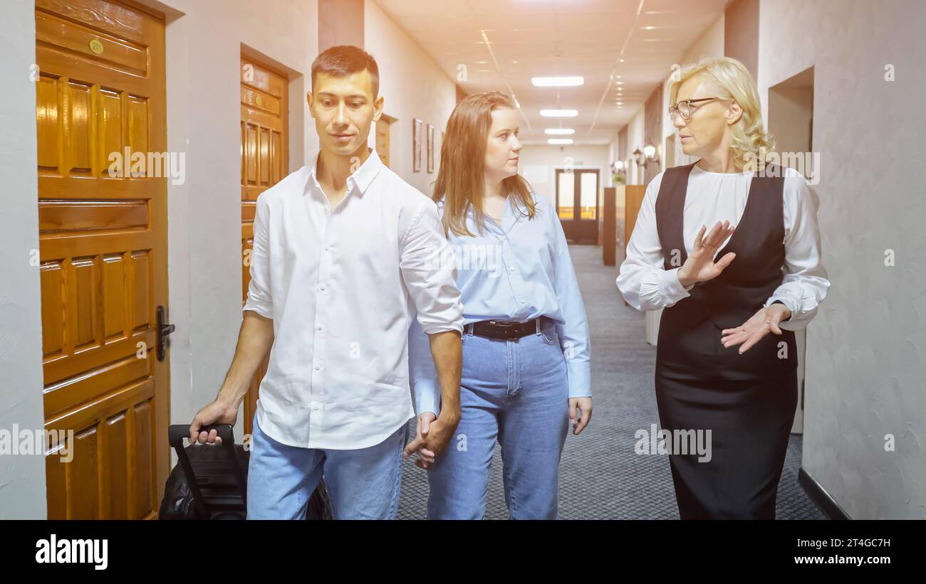 Receptionist leading young couple to booked hotel room Stock Photo - Alamy
