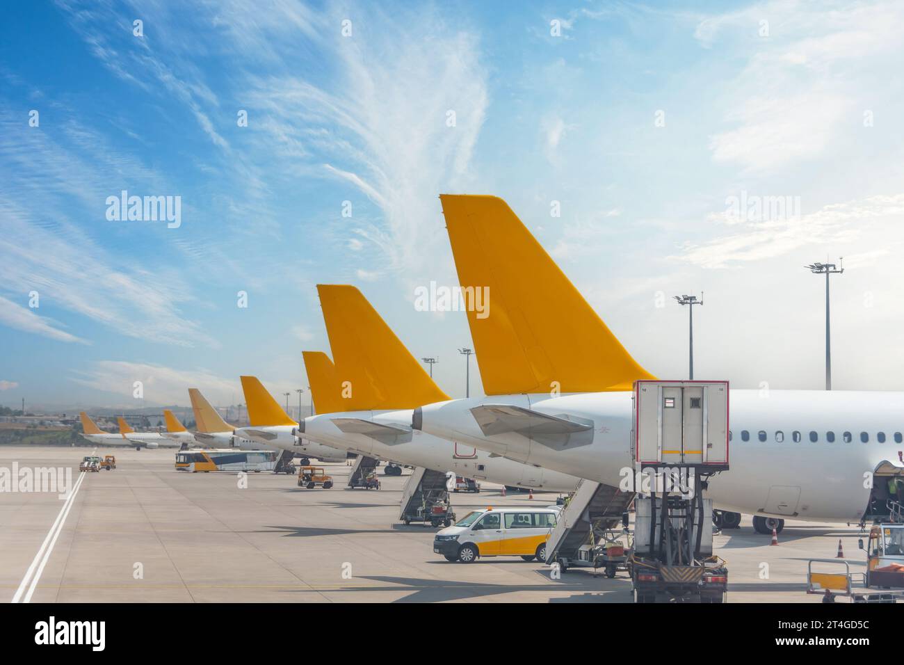 Passenger plane jets lined up in parking lots, tails view blue sky ...
